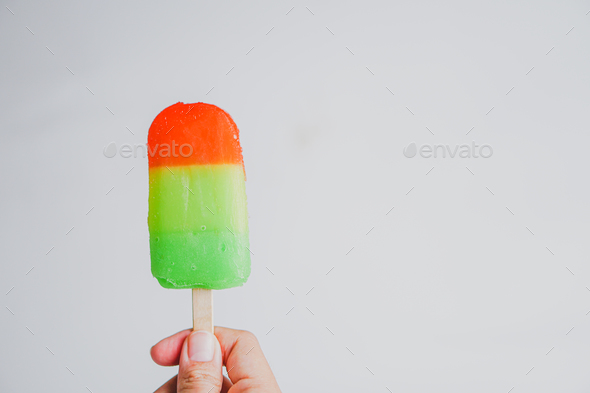 Rainbow popsicle stick ice cream in hand Stock Photo by Wdnld | PhotoDune