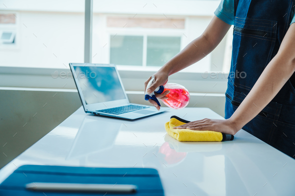 Cleans floor and desk. Hand of asian chinese woman wiping work desk ...