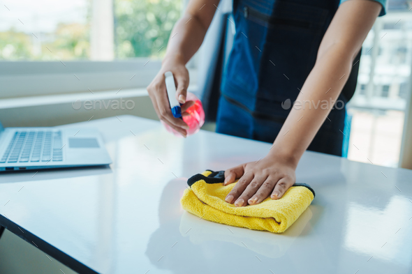 Cleans floor and desk. Hand of asian chinese woman wiping work desk ...