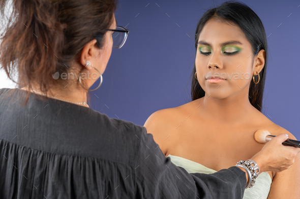 Applying highlighter on the chest of young model Stock Photo by GSR ...