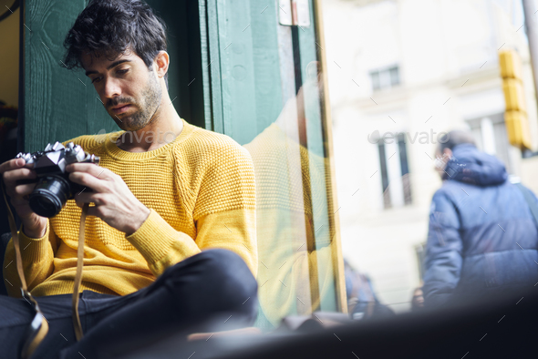 Adult male photographer setting camera for photo shoot camera while ...