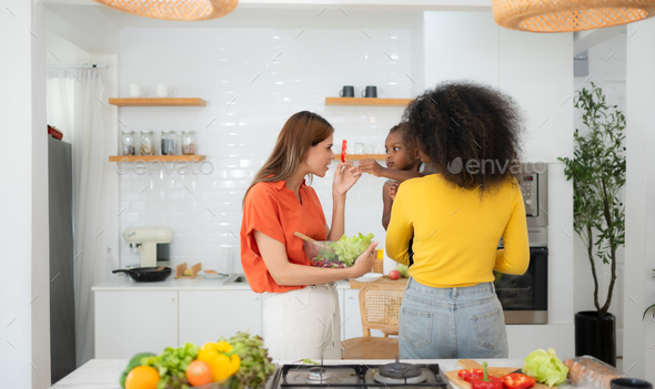 LGBT Couple and son cooking together in the kitchen at home Stock Photo ...