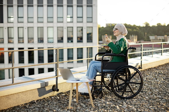 Muslim lady with disability eating food on roof terrace Stock Photo by ...