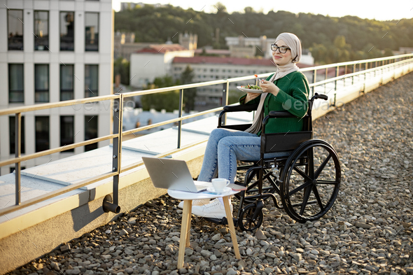 Muslim lady with disability eating food on roof terrace Stock Photo by ...
