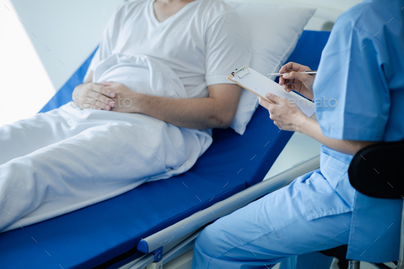 Patient on an inpatient hospital bed with a doctor examining and asking ...