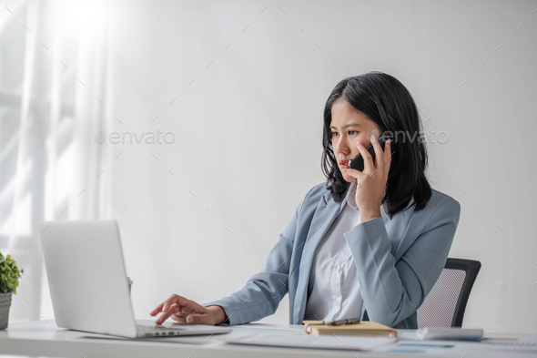 A smart and confident young Asian businesswoman or female banker in a ...