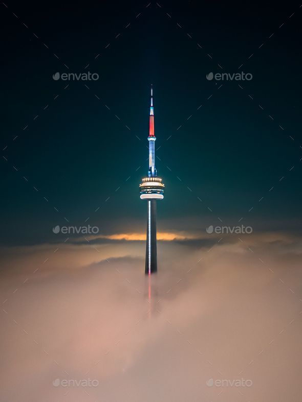 Majestic CN tower in Toronto illuminated by the night sky shrouded in a ...
