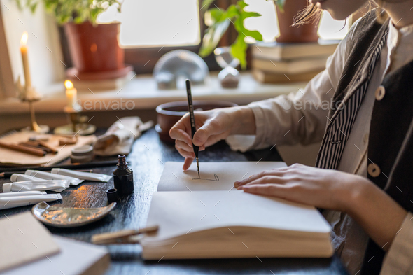 Female artist drawing with ink using dip pen, creativity and ...