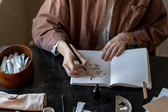 Artist drawing with black ink on white paper Stock Photo by varyapigu