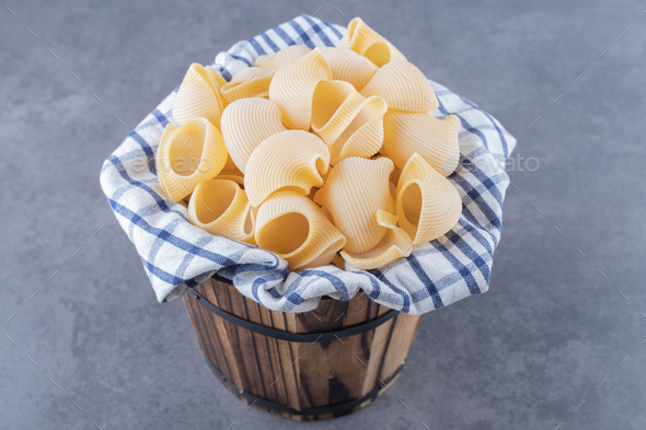 Bunch of raw shell pasta in wooden bucket Stock Photo by 13people ...