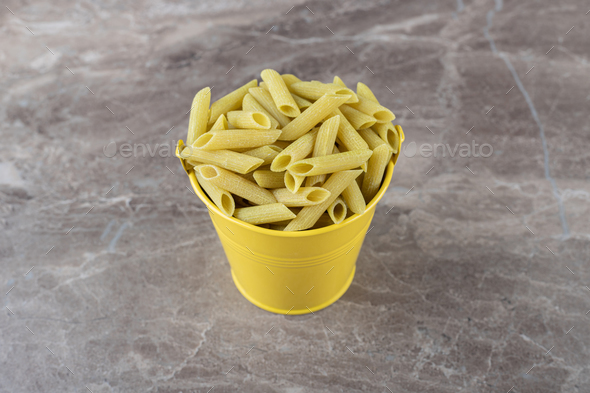 Pasta in yellow bucket , on the marble background Stock Photo by 13people