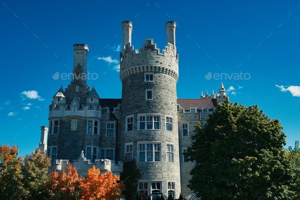 a tall castle sitting next to a green field with trees Stock Photo by ...