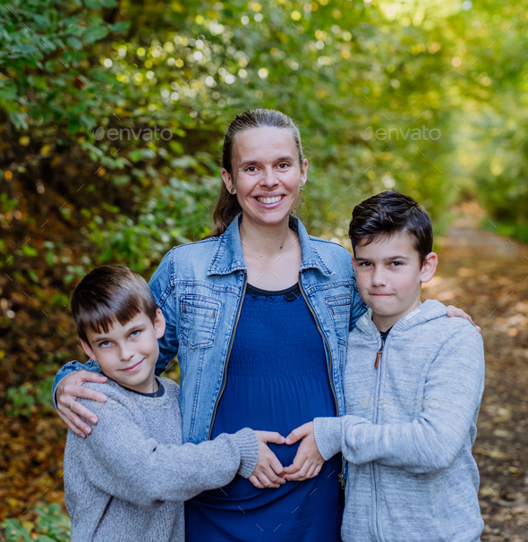 Portrait of pregnant mother and her sons, outdoor in forest. Stock ...
