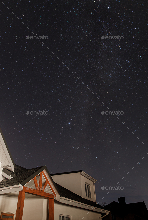 Amazing night sky with stars over modern farmhouse in countryside ...
