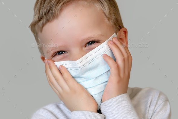 Smiling child with blond hair in the medical mask.Happy to protect ...