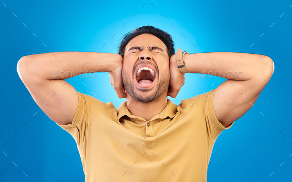 Man cover his ears while shouting in a studio for angry, upset or mad ...