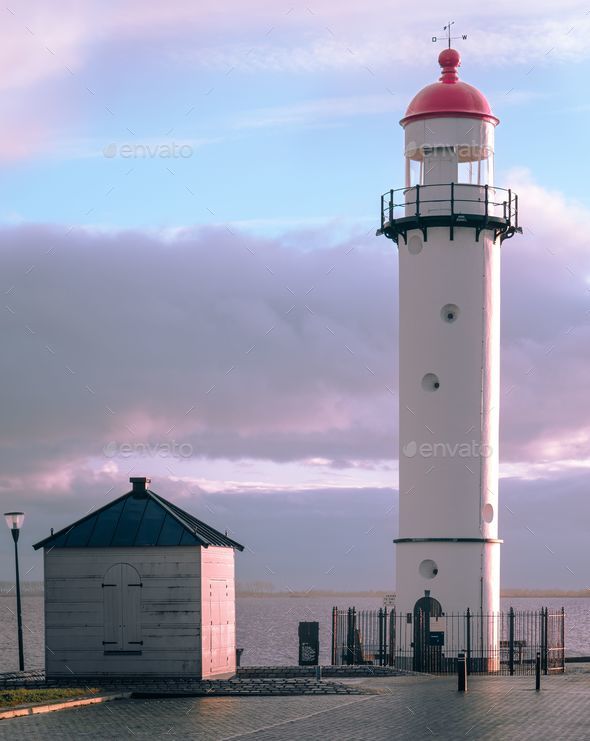 Lighthouse situated at the end of a pier surrounded by its iconic red ...