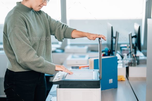 Female office worker using the printer at the office Stock Photo by ...