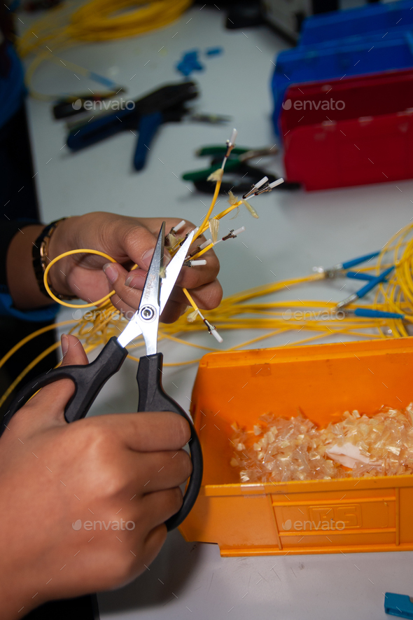 Technician cleaving an optical fiber, a crucial process for a good ...
