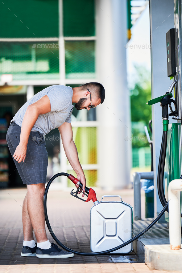 Side view of young driver filling canister with gasoline. Stock Photo ...