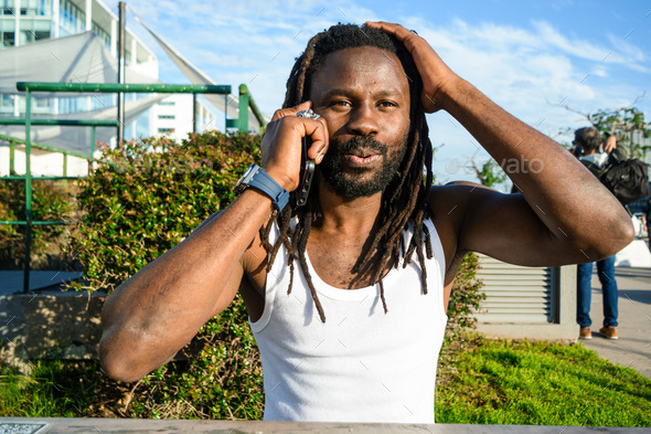 young black man with beard and dreadlocks shocked talking on the phone ...