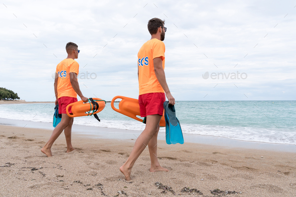 Lifeguard staff walking with a float watching on the beach Stock Photo ...
