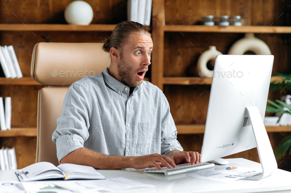 Shocked excited young adult Caucasian office employee, received an ...