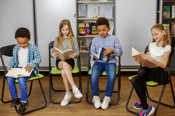 Group happy children reading book in classroom. Back to school. Study ...