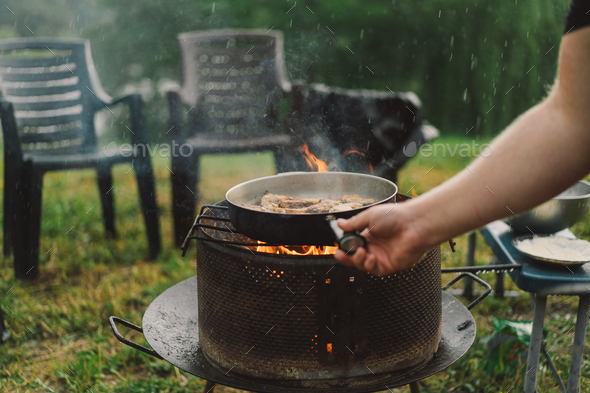 Man cooking fish on fire in nature, camping outdoors Stock Photo by ...