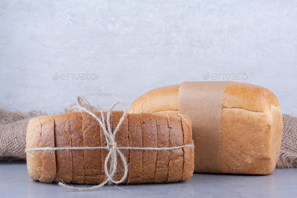 Whole and sliced blocks of bread on marble background Stock Photo by ...