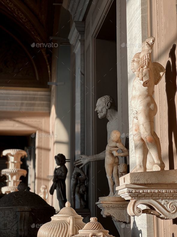 Vertical photograph of multiple ancient statues standing against a ...