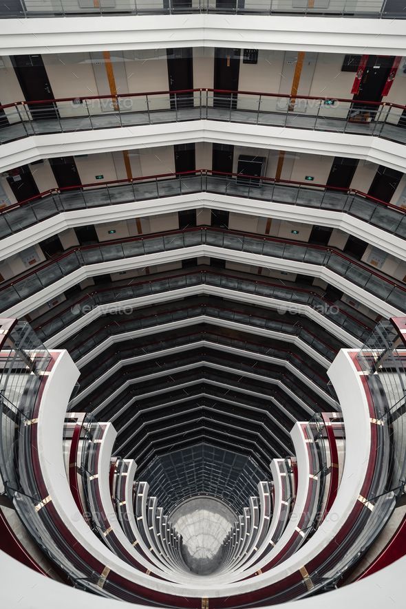 A multi-leveled atrium of a large building, with a modern, sleek design ...