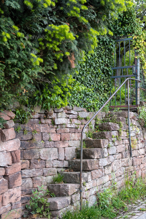 Narrow stone stair drives to closed metal gate. Germany, Heidelberg ...