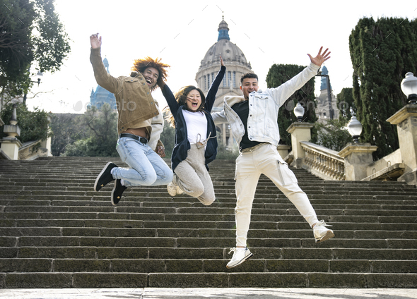 Three young diverse people jumping on a stairs. Multiracial group of ...