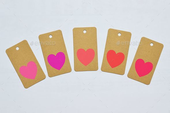 White background with six red heart-shaped tags scattered across it ...