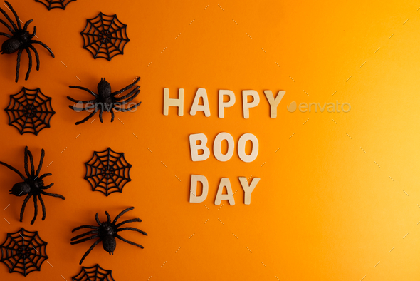 Happy Boo Day lettering on orange background with halloween decor ...