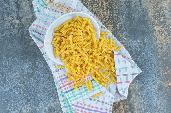 Pasta falling from the overturned bowl , on the marble background Stock ...