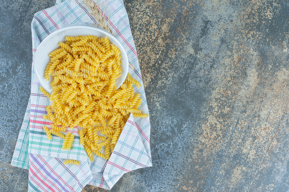 Pasta falling from the overturned bowl , on the marble background Stock ...