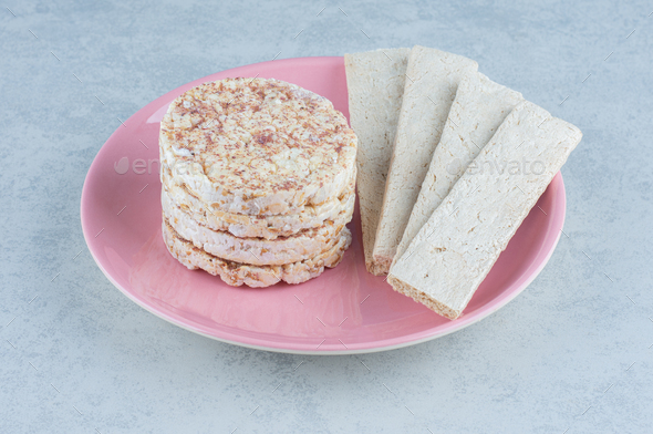 Puffed rice cakes and sweet cracker in the plate, on the marble ...