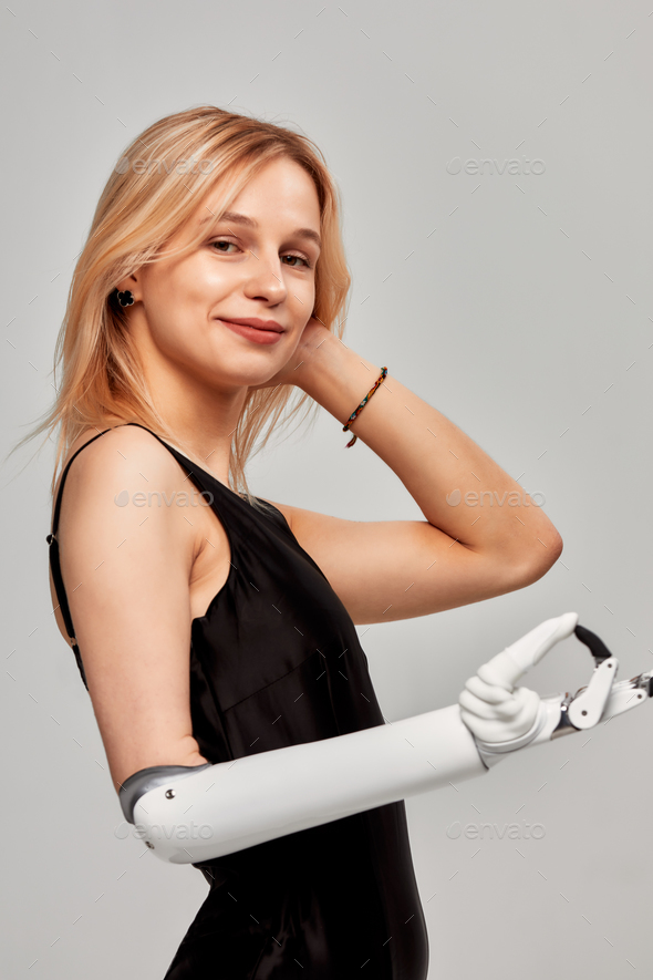 Studio portrait of beautiful young blonde girl with disability wearing ...