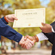 Shaking hands, graduation and certificate for college student with ...