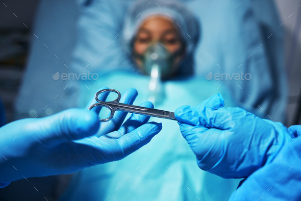 Hands, scissors for operation and a surgeon team with a patient in the ...