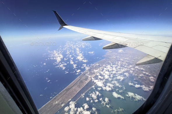 View through airplane window of commercial jet plane wing flying high ...