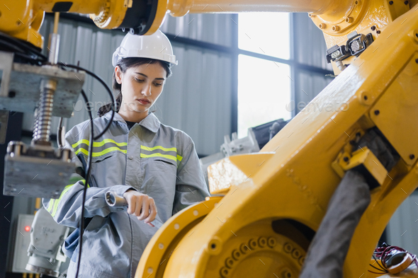 Engineers woman using wrench maintenance robotic arm. Female technician industrial checking ...