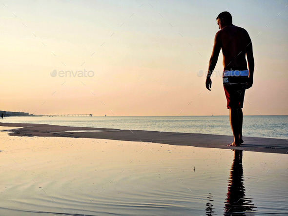 Solitary man generation X walking on beach in morning routine for ...