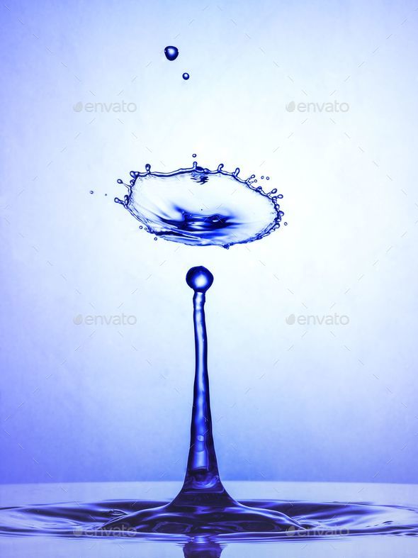 Abstract closeup of a single water droplet falling and making a splash ...