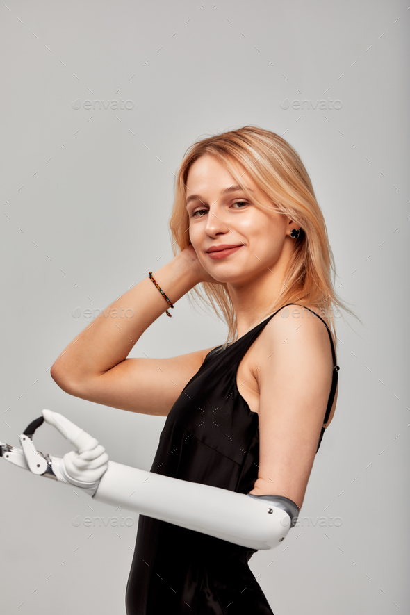 Studio portrait of beautiful young blonde girl with disability wearing ...