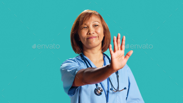Assertive nurse throwing stop hand sign Stock Photo by DC_Studio ...