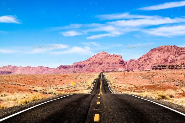 A highway running towards mountains in the Western areas of the USA ...