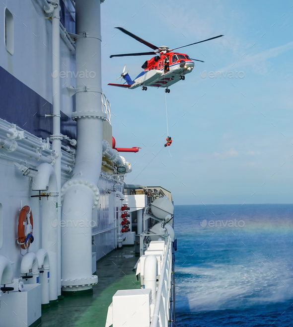Air-sea rescue operations. Red rescue helicopter and Oil Tanker Ship ...